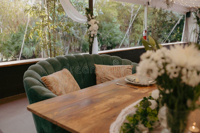 Small, Intimate Dining Area with a Curved, Emerald Green Sofa and a ...