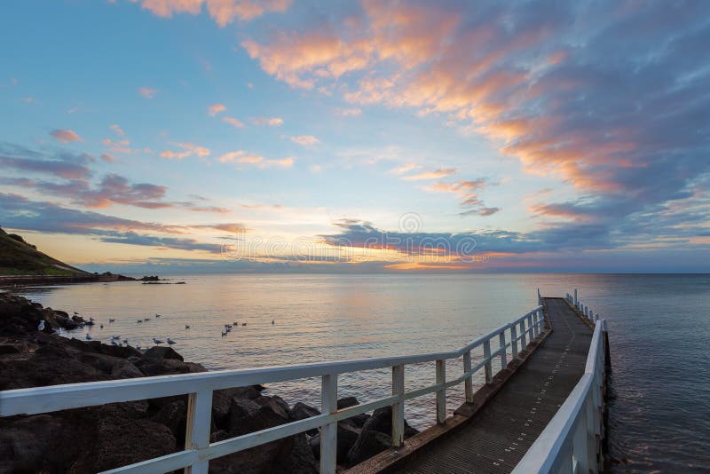 Small Pier Extending into Silky Smooth Ocean at Sunset. Stock Photo ...