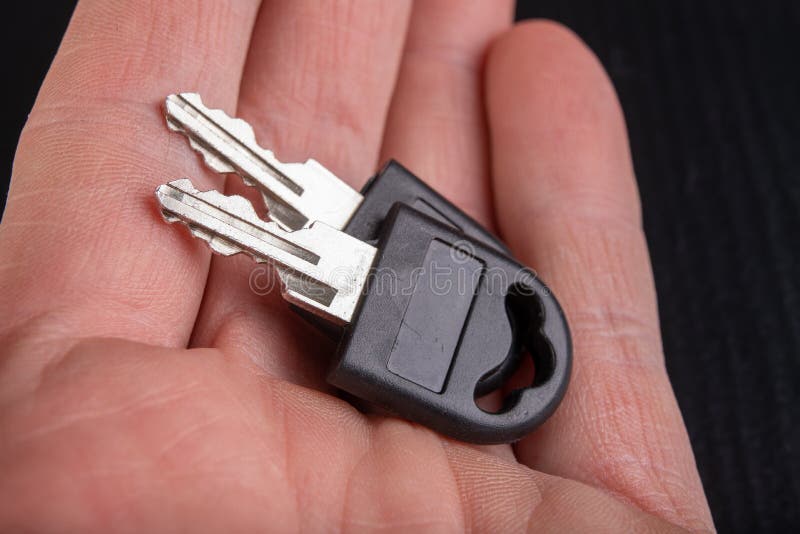 A Small Key with a Plastic Handle and a Lock on the Male Hand ...