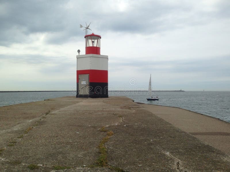 Small Lighthouse at the End of a Long Concrete Pier, Its Bright Light ...