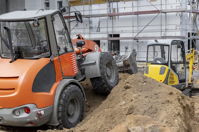 Small Loader and Excavator Digger Machine Moving Heap of Earth and ...