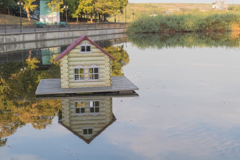 A Small Log House Floating on the Water of an Urban Lake Stock Photo ...