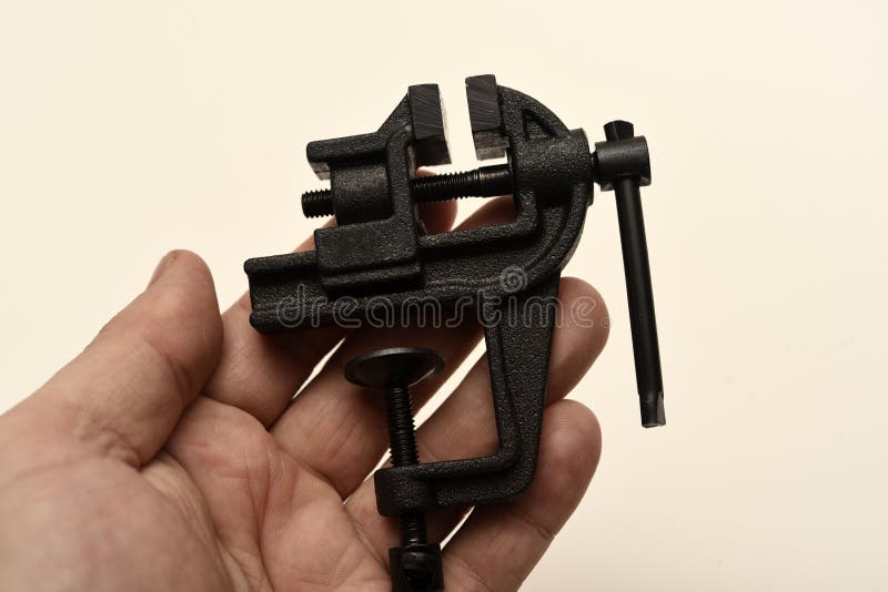 A Small Metal Vise in His Hand. the Clamp Stock Photo - Image of ...