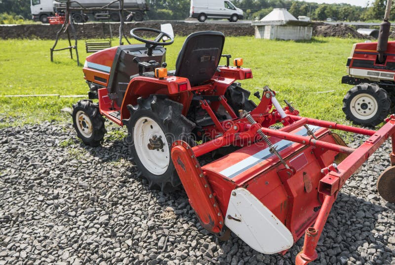 A Small Mini Red Tractor Stands on a Farm Yard on Green Grass and Waits ...