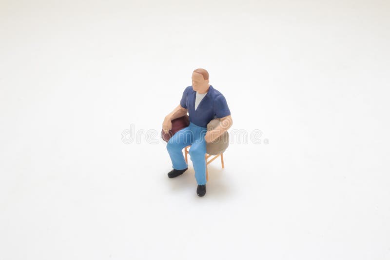 Small Miniature Figure Figure Seated on Chair Stock Photo - Image of ...