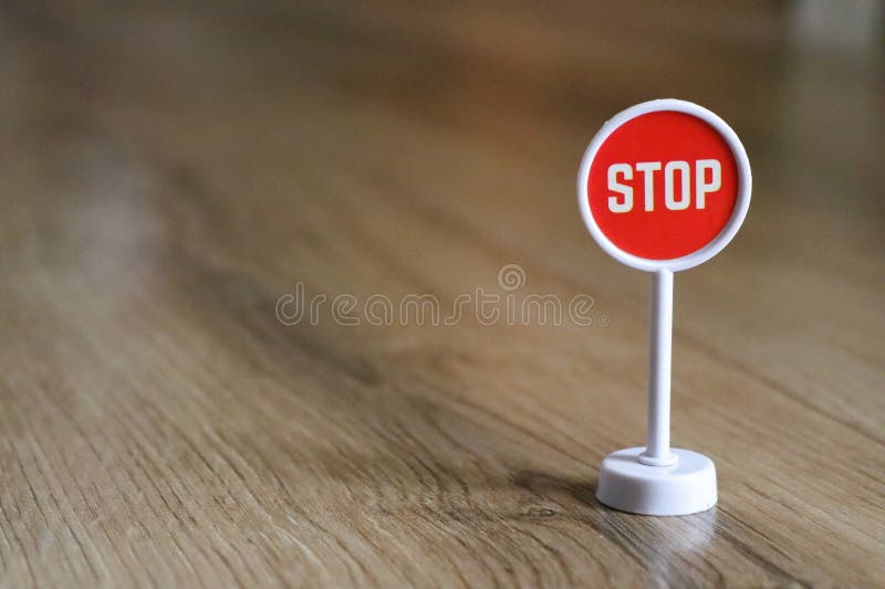 A Small Miniature Stop Sign Placed upon a Wooden Floor Surface for ...