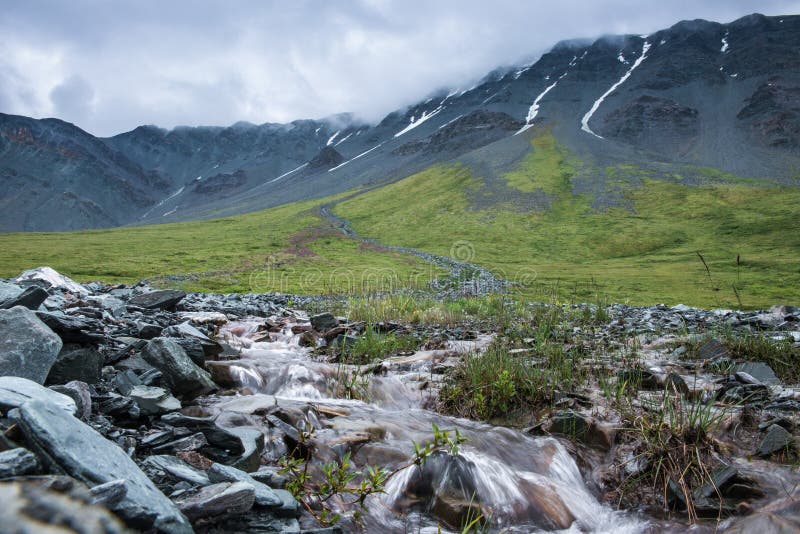 A Small Mountain Stream Flows through the Rocks Stock Photo - Image of ...