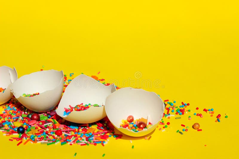 Small Multi-colored Sweets in a Broken White Egg Shell on Yellow ...