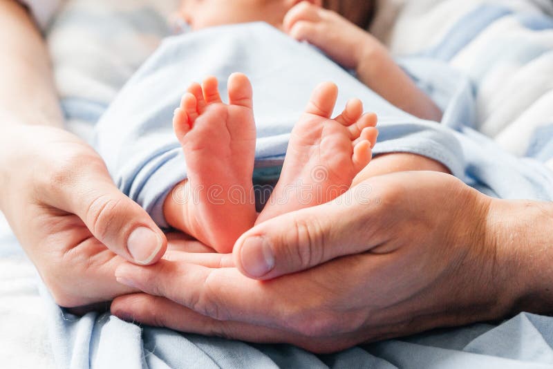 Small Newborn Baby Legs In The Hands Of Parents. Stock Photo - Image of ...