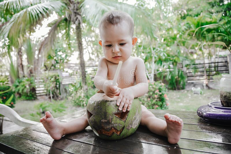 A Small One Year Old Child Thoughtfully Plays with the Symbol of ...