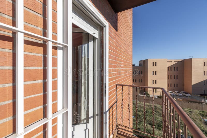 A Small Open Terrace with a Metal Railing and Views of an Open Field ...