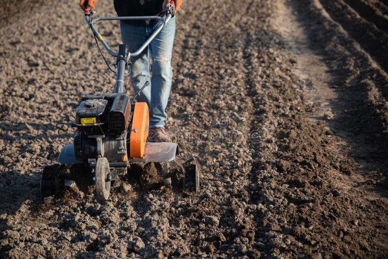 Small Plowing Machine in Hands of a Farmer Making Arable in Black Soil ...