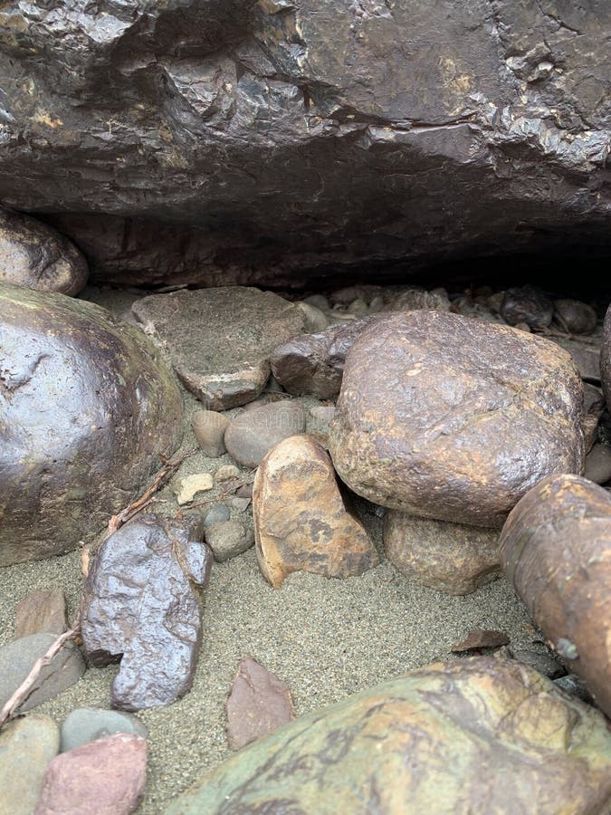 Small Pebbles and a Large Rock on the Beach with a Smooth Surface and ...