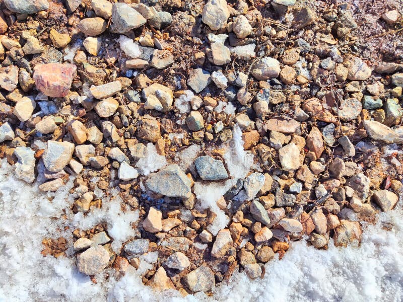 Small Pebbles in the Snow As a Background and Texture. Heart-Shaped ...