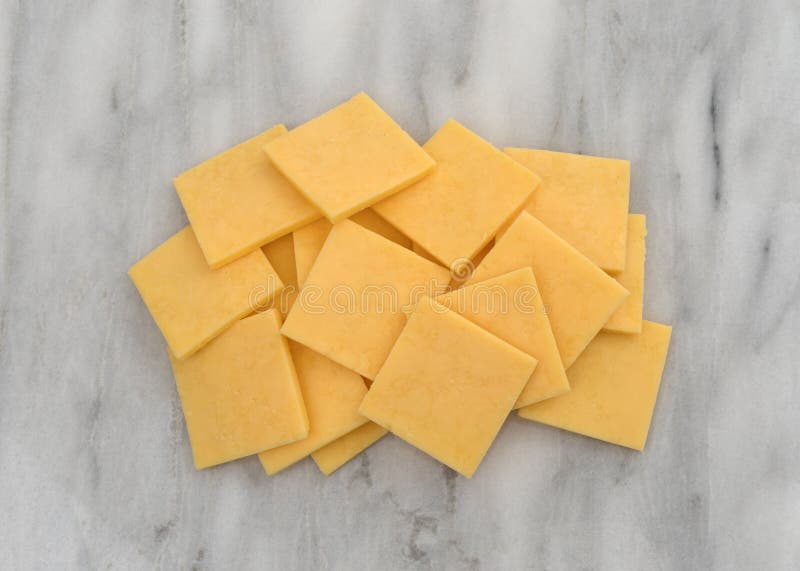 Group of Gouda Cheese Slices on a Cutting Board Stock Photo - Image of ...