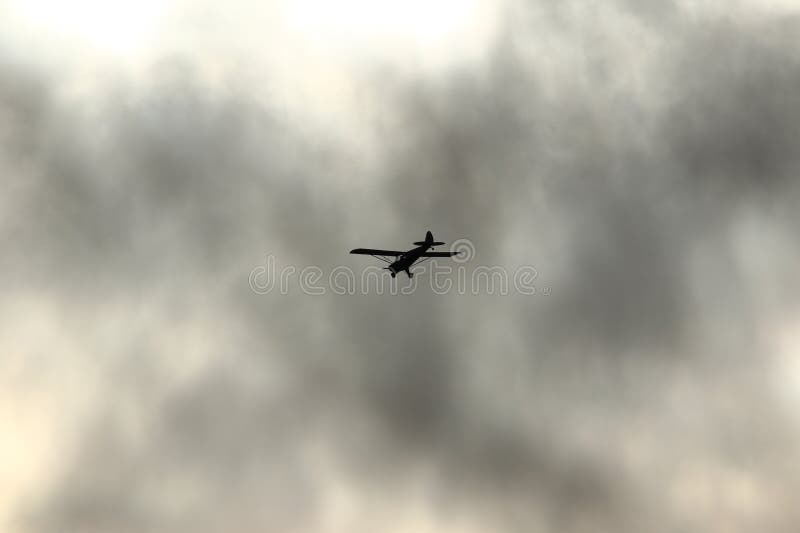 Small Plane Flying in the Sky Against Dark Clouds Stock Image - Image ...