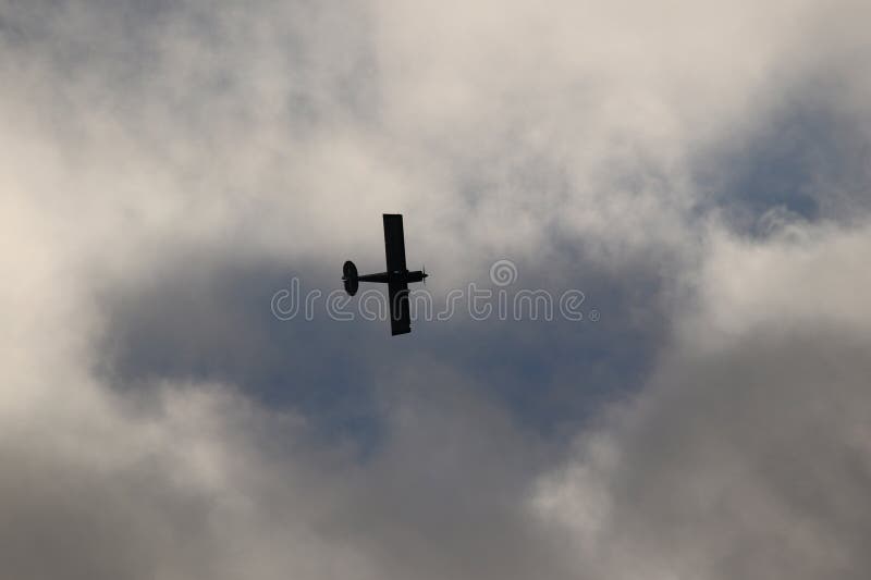Small Plane Flying in the Sky Against Dark Clouds Stock Image - Image ...