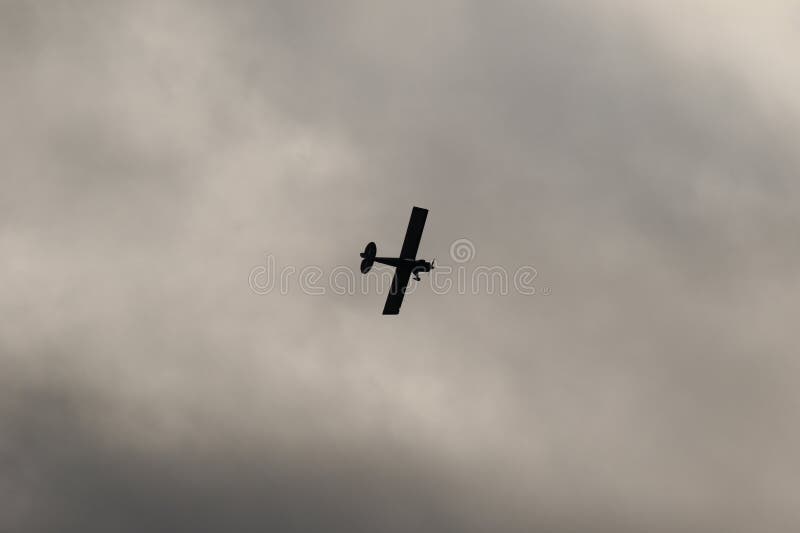 Small Plane Flying in the Sky Against Dark Clouds Stock Photo - Image ...