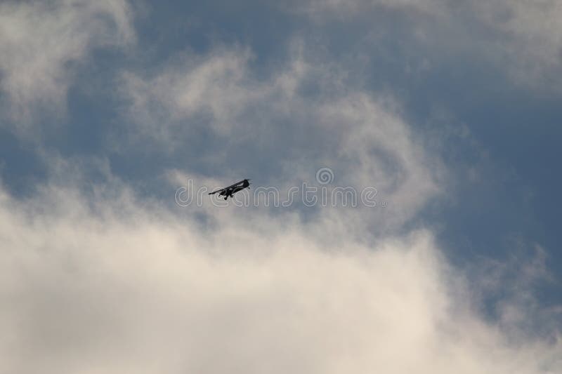 Small Plane Flying in the Sky Against Dark Clouds Stock Image - Image ...