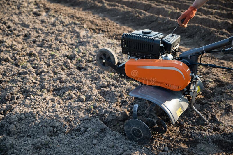 Small Plowing Machine in Hands of a Farmer Making Arable in Black Soil ...