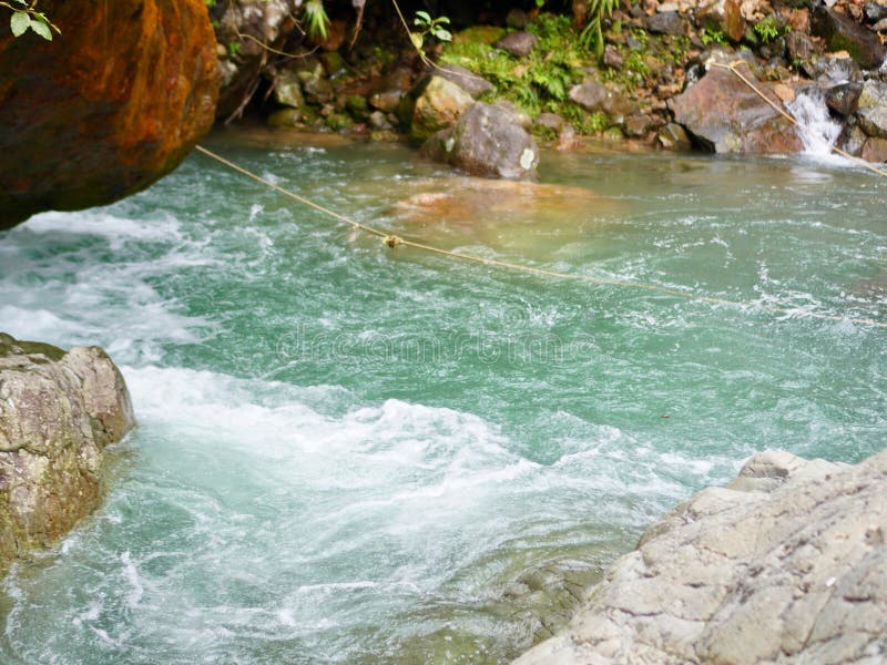 A Small yet Powerful Stream Flows Under a Dramatic Rock Face in a ...