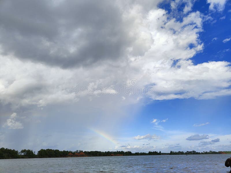Small Rainbow in the Sky with Sky Background and View of River and ...