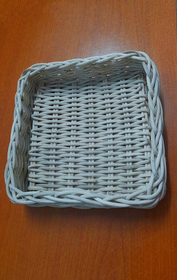 A Small Rattan Basket of Bright Color is Placed on a Brown Table Stock ...