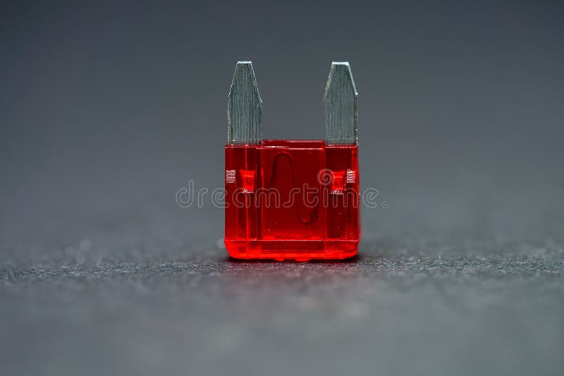 Small Red Automotive Fuse on a Black Surface, Highlighting Its Design ...
