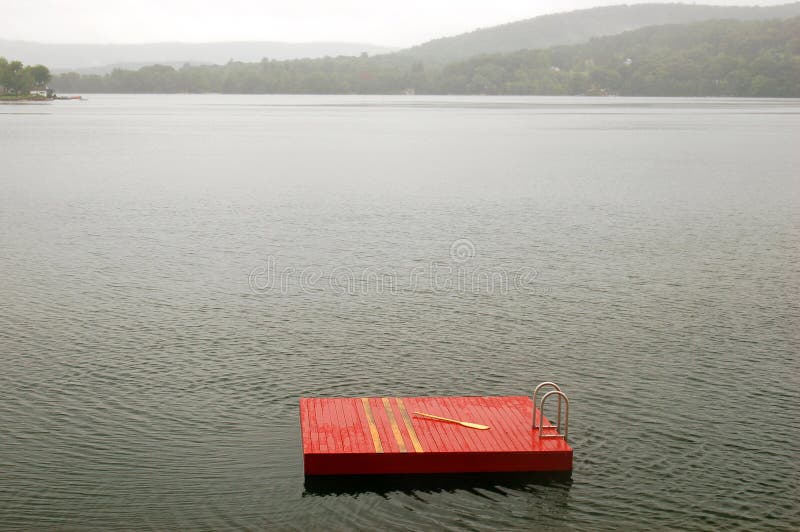 A Small Red Platform with an Oar Sits in the Middle of a Foggy Lake ...