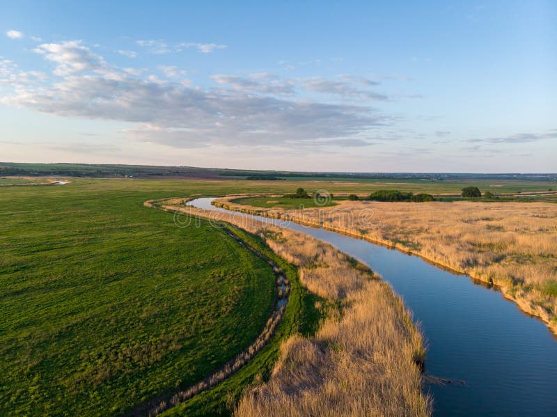 Small River Meanders in the Midst of Green Fields and Meadows at Sunset ...