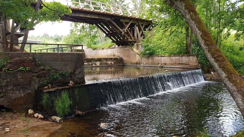 On Small River There is an Artificial Waterfall Under Wooden Bridge in ...