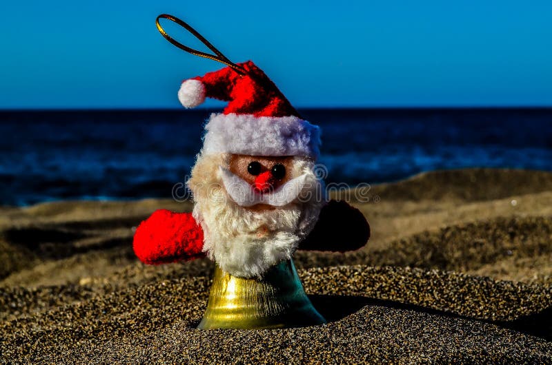 A Small Santa Claus Figurine is Sitting on a Beach Stock Photo - Image ...