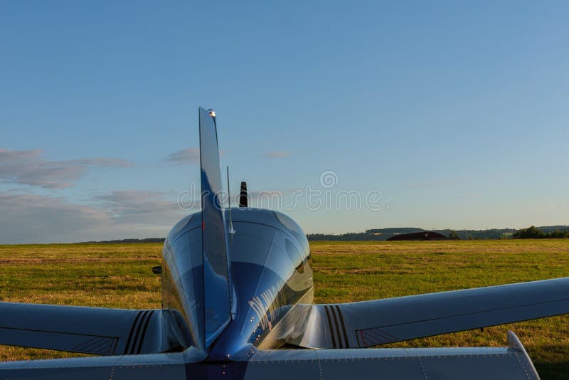 A Small 2-seater Plane Against a Blue Sky with White Clouds. Back View ...