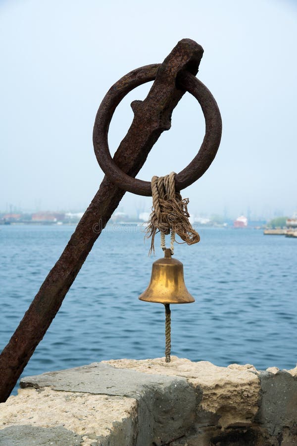 Small Ship Bell Hanging on a Rope from an Old Rusty Anchor. Sea ...