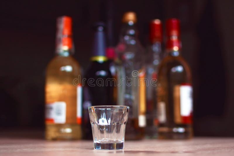 Small Shots Glass in Front of Multiple Blurry Different Strong Spirits ...