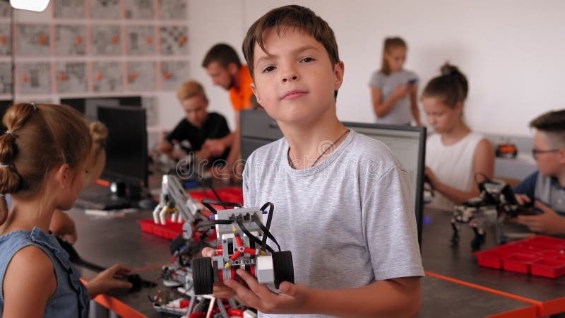 A Small Smart Boy Holds a Robot in His Hands in the Robotics Office ...