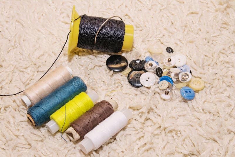 Small Spools of Thread of Different Colors and a Bunch of Buttons Lie ...