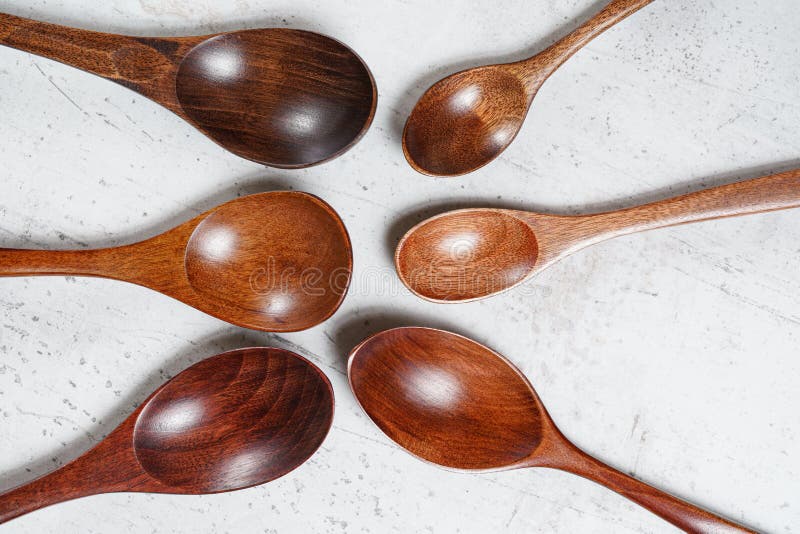Small Spoons Made of Dark Wood, on White Working Board, View from Above ...