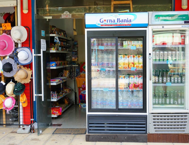 A Small Store with a Glass Front and a Few People Standing Outside ...