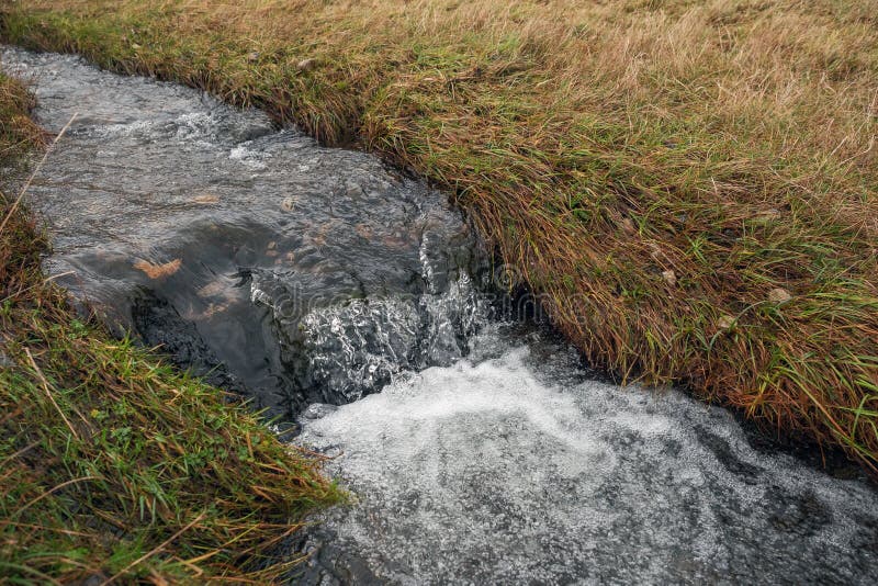Small stream in a field. stock photo. Image of mountain - 175747720