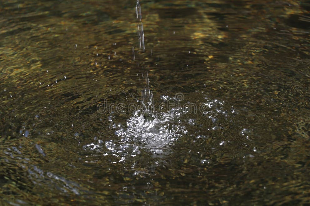 Small Stream of Water Falling in a Pond and Creating Ripples Stock ...