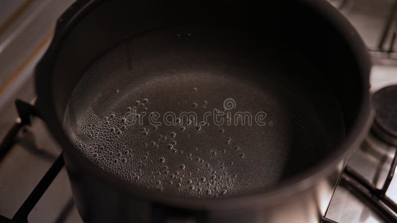 Small Tiny Bubbles Forming on Surface of Water As Heats in Pot on Stove ...