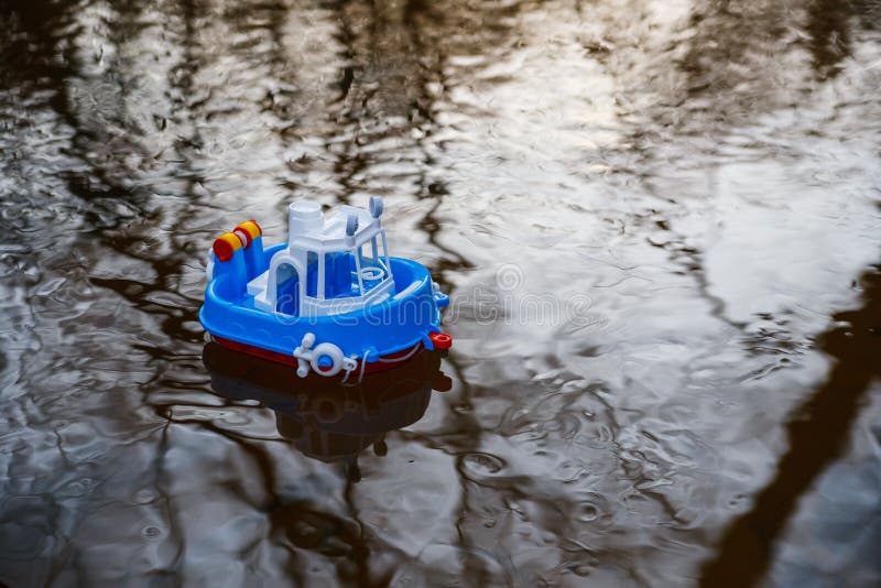 A Small Toy Boat Sails Along a Forest River at Sunset Stock Photo ...