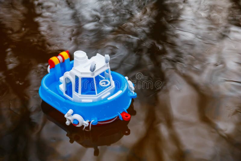 A Small Toy Boat Sails Along a Forest River at Sunset Stock Image ...