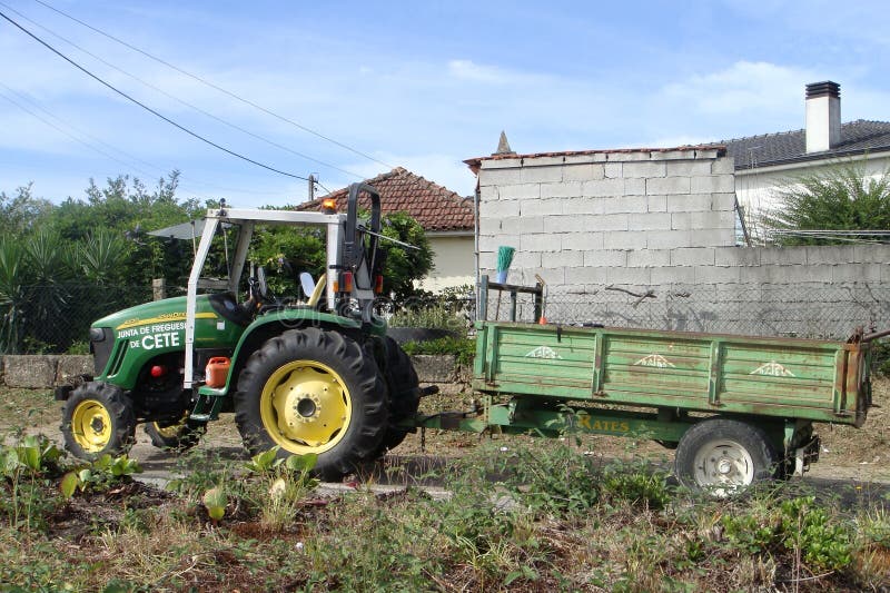Green Tractor Pulling a Trailer in a Rural Area Editorial Stock Image ...