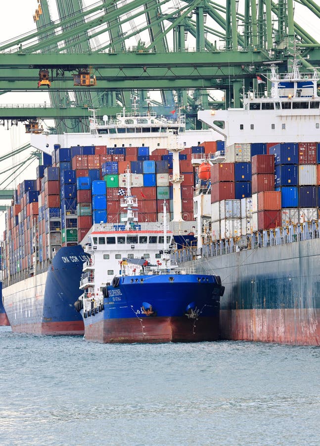 A Small Transport Ship Docks Next To a Large Container Ship Editorial ...