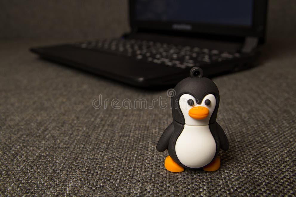 Small Tux Toy at Blurred Notebook Background. Stock Image - Image of ...