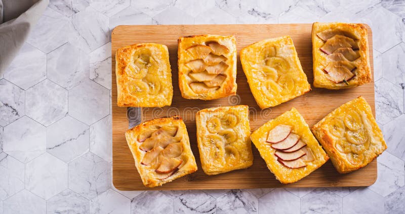 Small Upside-down Puff Pastry Cakes with Banana and Apple on a Board ...