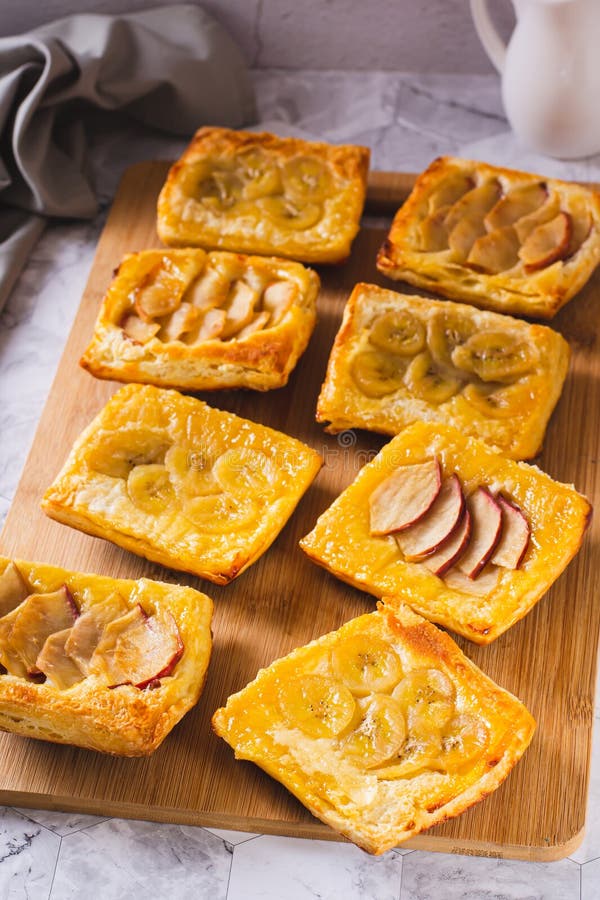 Small Upside-down Puff Pastry Cakes with Banana and Apple on a Board ...