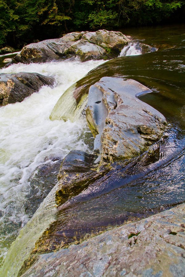 Small Waterfall Cascading Over Rocks into a White Water River Stock ...